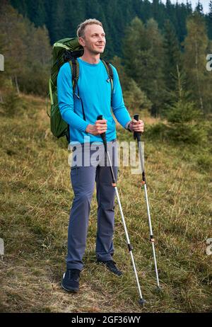 smiling young man with hiking sticks Stock Photo - Alamy