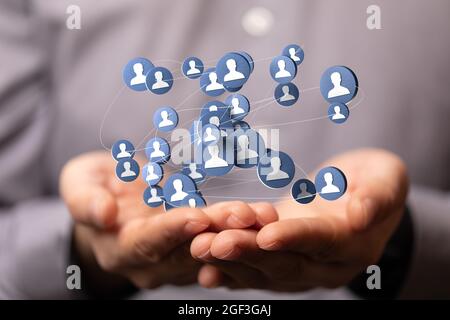 Closeup of people symbols floating above a man's hands, digital ...