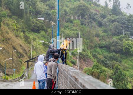 BANOS, ECUADOR - JUNE 20, 2015: People performing bridge jumping ...