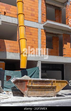 Chute and Skip for Debris at Construction Site Stock Photo - Alamy
