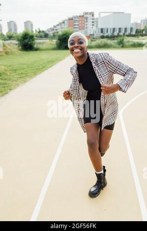 smiling woman running on track outdoors Stock Photo - Alamy