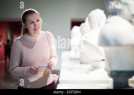 woman with guidebook standing in museum Stock Photo - Alamy