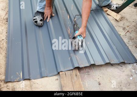 Building contractor is cutting lightweight metal, steel, edge trim with ...