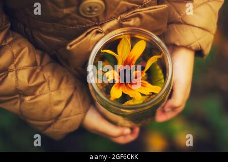 Girl keeps Bottle filled autumn treasures with empty paper label Stock ...