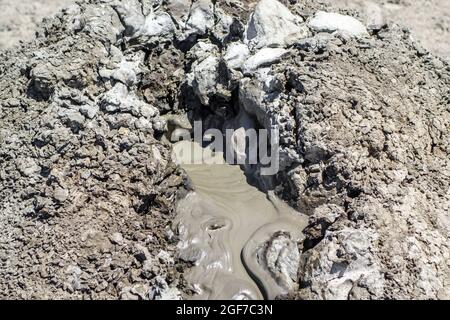 Close up view on crater of mud volcano. Slow flow of underground mud ...