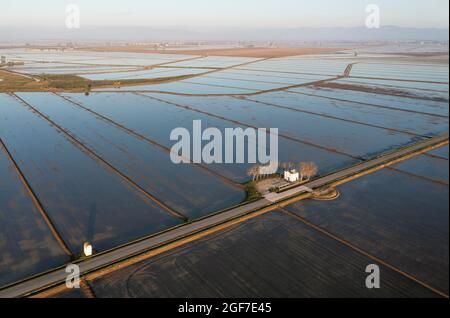 Small farm cottage amidst flooded rice fields in May, aerial view ...