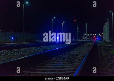 Night empty railroad tracks near train station with lights in dark ...