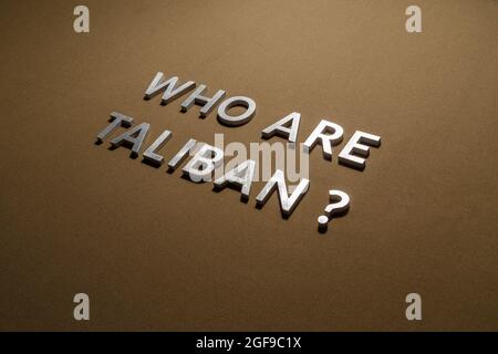 the question who are taliban laid with silver metal letters on rough ...