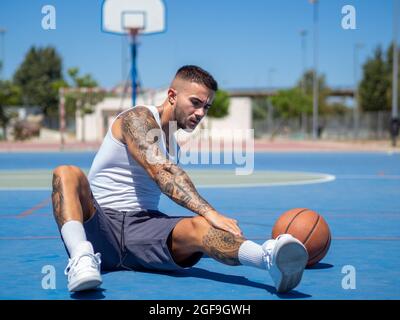 Athletic handsome Spanish basketball player training on a basketball ...