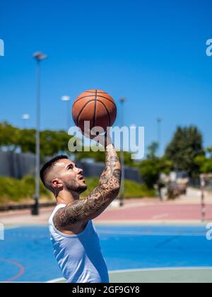 Athletic handsome Spanish basketball player training on a basketball ...