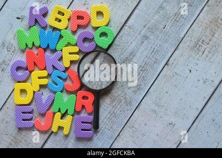 Magnifying glass and Colorful Letters of Alphabet Stock Photo - Alamy