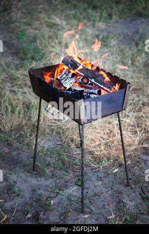 A small folding portable brazier filled with woods Stock Photo - Alamy
