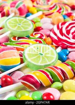 Colorful lollipops and different colored round candy on grey wooden ...