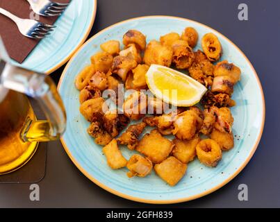 Chipirones, breaded fried calamari with lemon Stock Photo - Alamy