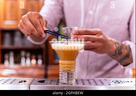 Barman decorating alcoholic drink called irish coffee Stock Photo - Alamy
