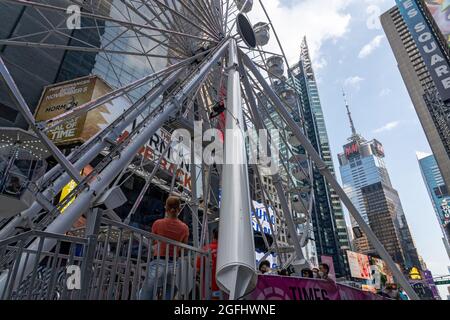 People ride the Times Square Ferris wheel on opening day in Times ...