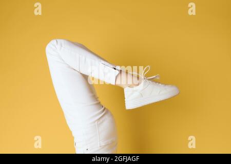 inverted legs in white sneakers fashion modern style yellow background ...