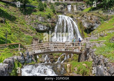 Hikers at the waterfall in front of the St. Beatus Caves, Beatenberg ...