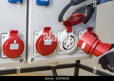 Industrial sockets and plug on distribution board. Construction site electricity, temporary ...