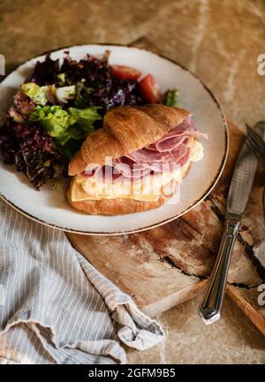 Croissant sandwich with fried egg, smoked salmon, green cheese and ...