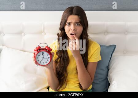 Worried about being late. Anxious girl hold alarm clock. Time late ...