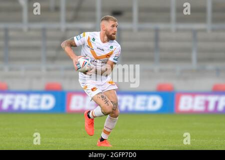 Sam Tomkins (29) of Catalans Dragons is held up by Lewis Dodd (21) and ...