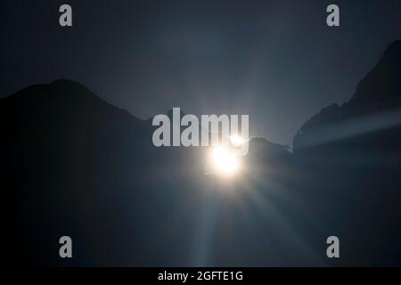 summer solstice landscape of alps. day meet night. sun and moon over ...