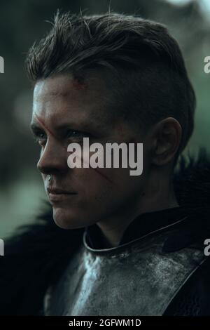 Portrait of medieval warrior knight with bloody face and scar in armour ...