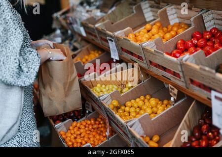 Young woman choosing tomatoes in grocery store Stock Photo - Alamy