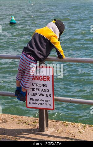 Do Not Climb warning sign on railing of cruise ship Stock Photo - Alamy