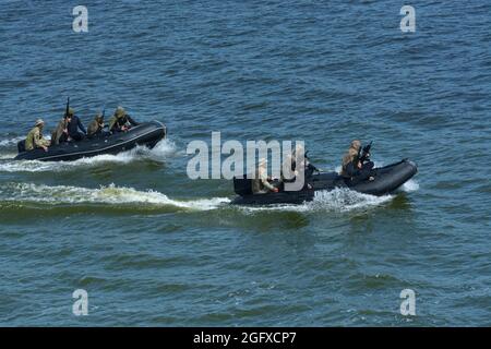 Miltary boat floating on water, armed soldiers of Special Forces aboard ...