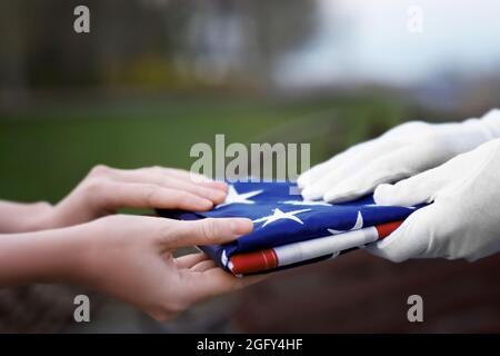 Folded into triangle American flag on memorial marble tomb with R.I.P ...