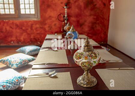 Traditional Middle Eastern dining setting with woven mats on tables and ...