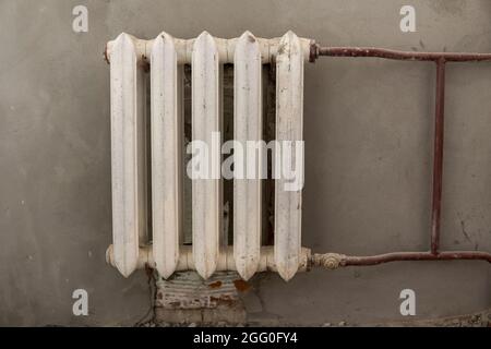 Old painted heating radiator. Pink dirty color. View from the front ...