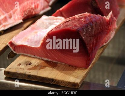 Slabs of freshly sliced tuna in a Tokyo Fish market. Tuna is well ...