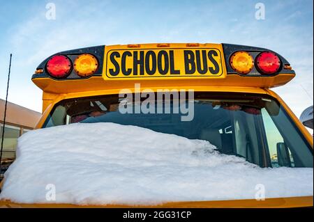 A snow-covered school bus driver makes his way during a snowy day in ...