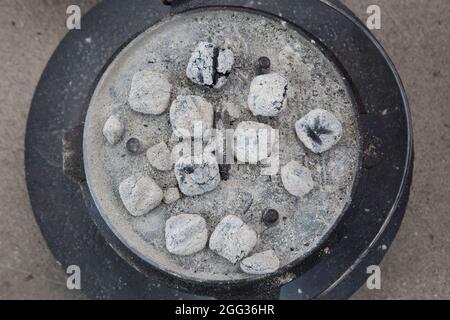 Bowl with the light gray coal for cooking in it Stock Photo - Alamy