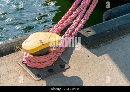 A closeup shot of yellow rope tied on a yacht against a blurred ...