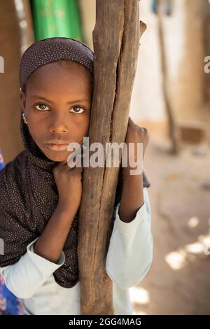 A family of traditional Fulani cattle herders stand together outside ...