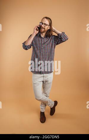 Ginger white man talking on cellphone and expressing surprise isolated ...