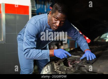 Professional man car mechanician repairing car in auto repair Stock ...