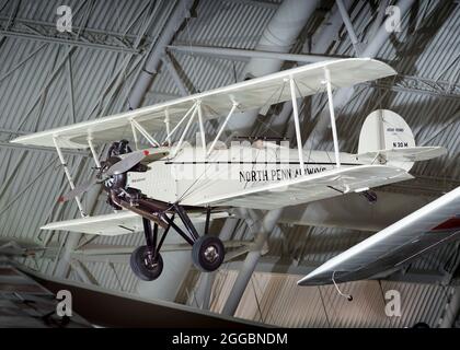 Three-place, open-cockpit biplane with red, white and blue paint scheme ...