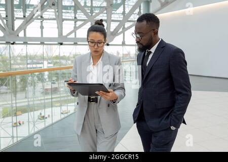 Young elegant female economist explaining financial fluctuations graph ...
