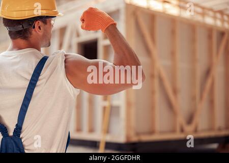 Athletic young man builder demonstrating his muscular arm Stock Photo ...
