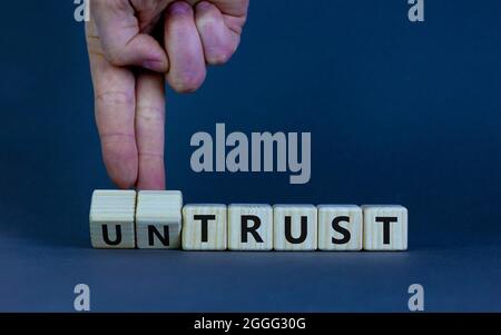 Untrust or trust symbol. Businessman turns wooden cubes, changes words ...