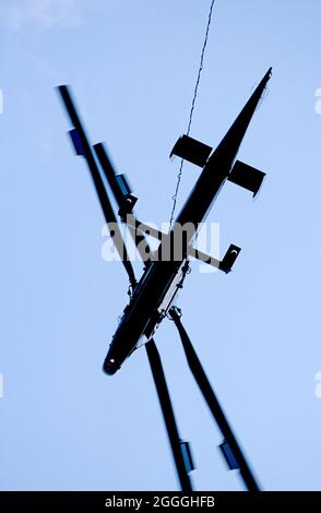 A Kaman K-1200 K-MAX heavy lift helicopter removing debris on a ...