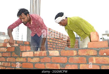 Manual Workers doing laborious job at a rural construction site in New ...