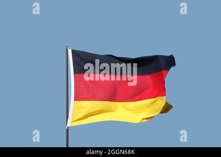 German flag flying on flagpole on blue sky background Stock Photo - Alamy