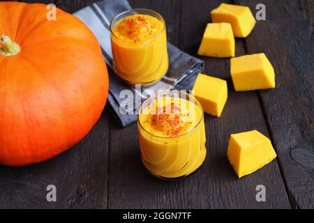 Pumpkin smoothie with spices on a wooden background Top view. Copy ...