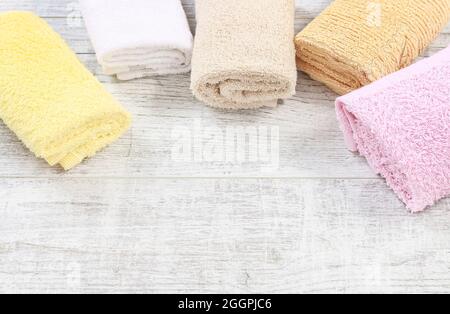 Colorful towels on wooden table on window background Stock Photo - Alamy